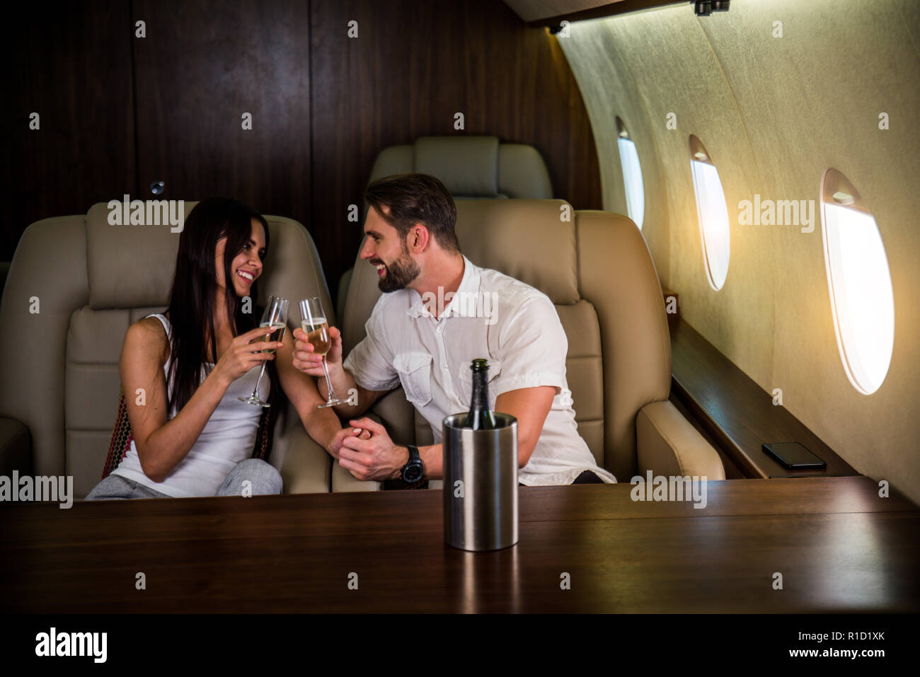 Happy couple travelling on a luxury private jet - Young adults travel ...
