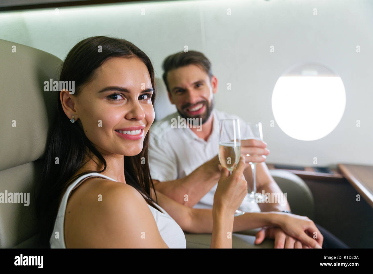 Happy couple travelling on a luxury private jet - Young adults travel ...