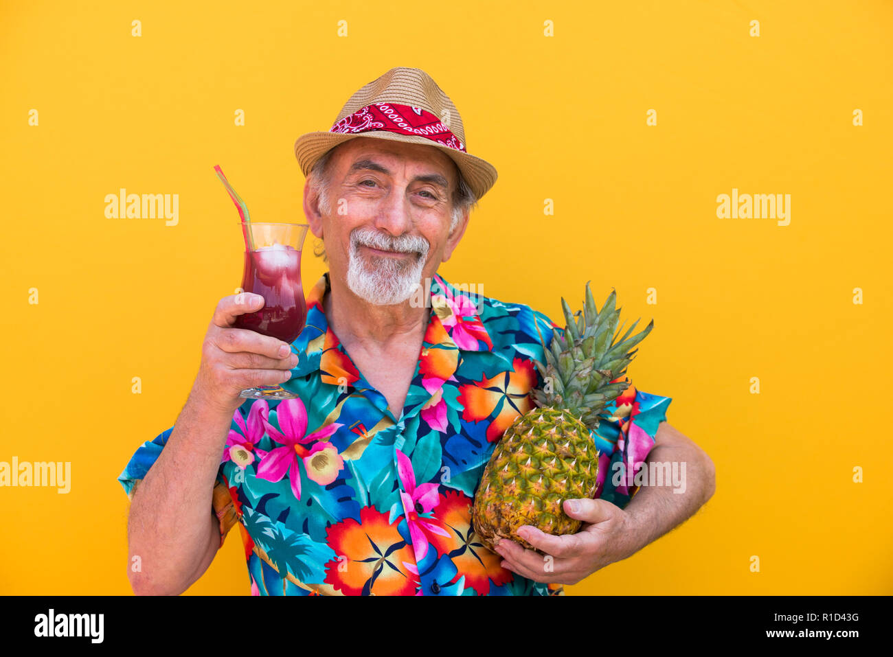 Funny and extravagant senior man posing on colored background ...