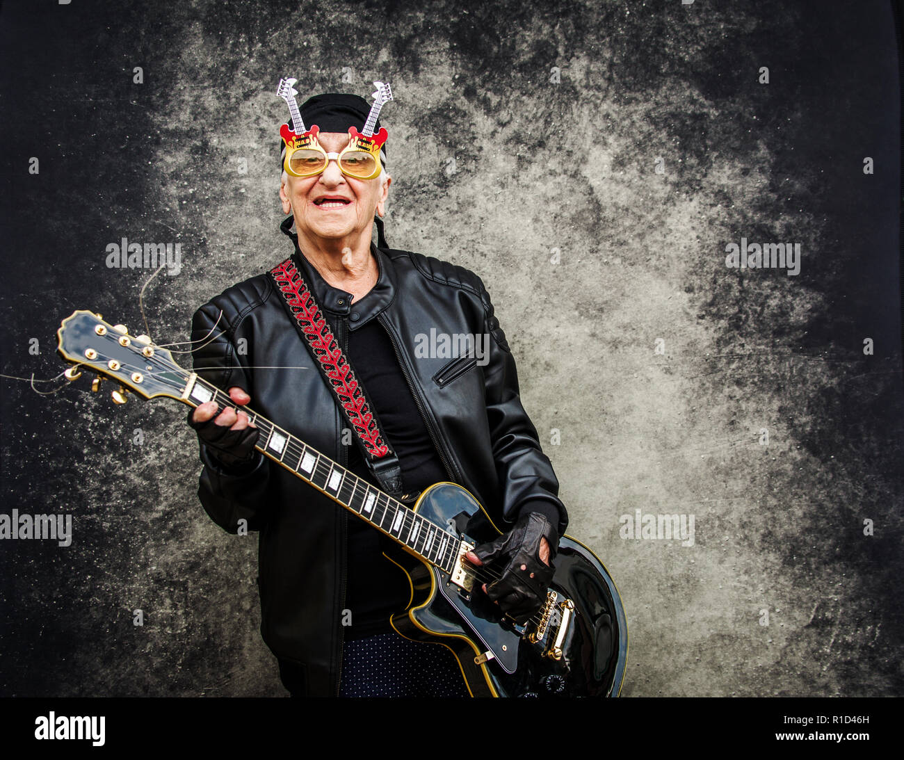 Funny and extravagant senior woman posing on colored background ...