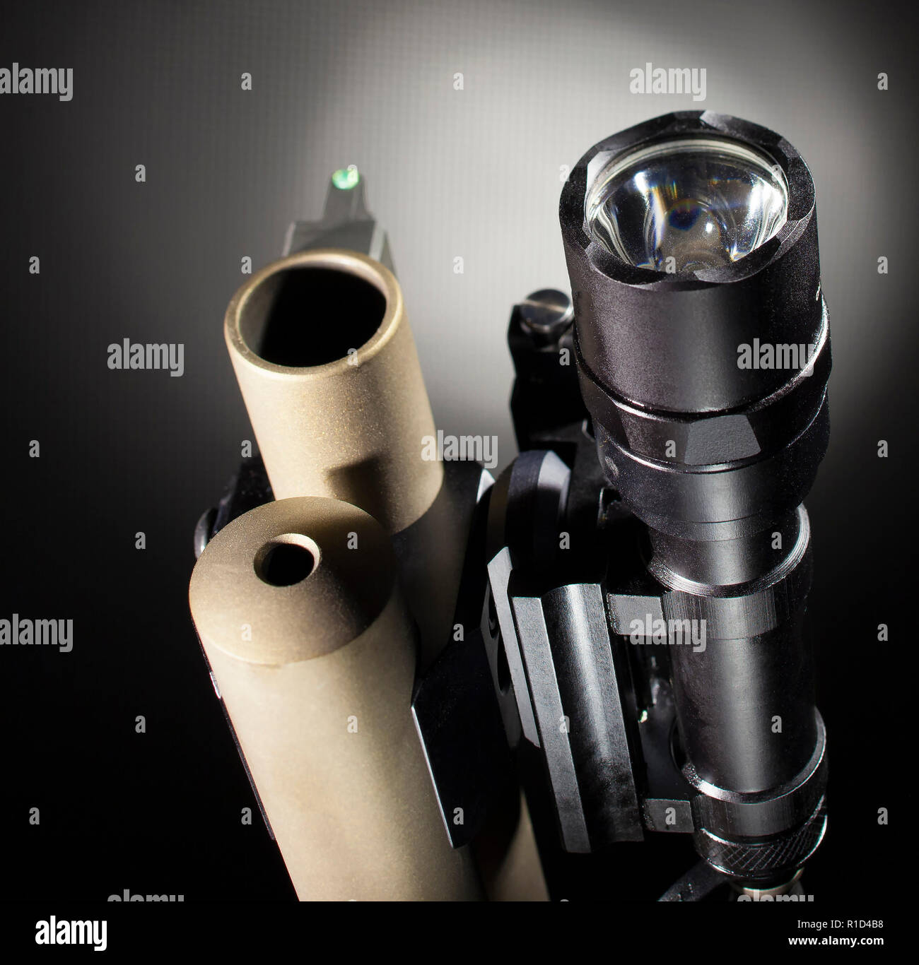 Front of a pump action shotgun with a flashlight attached to the barrel ...