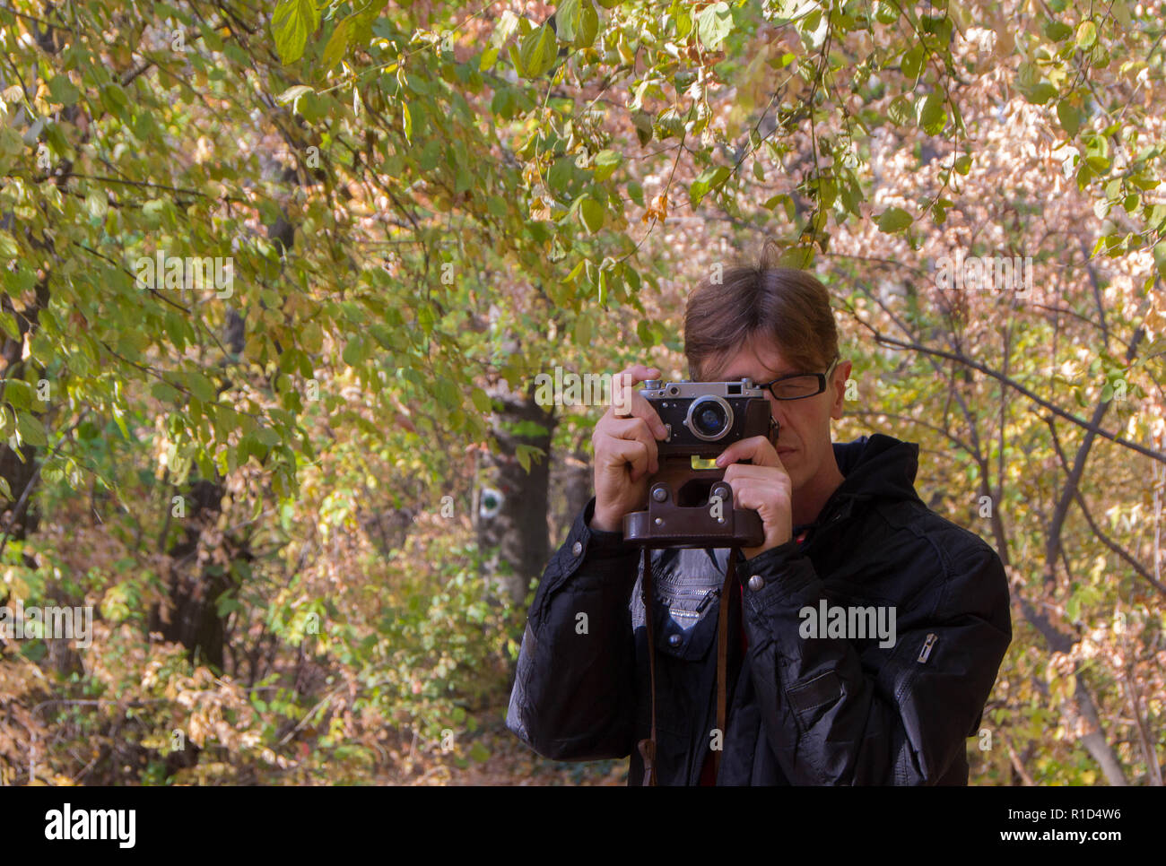 A man takes pictures with the old Soviet rangefinder film camera FED ...