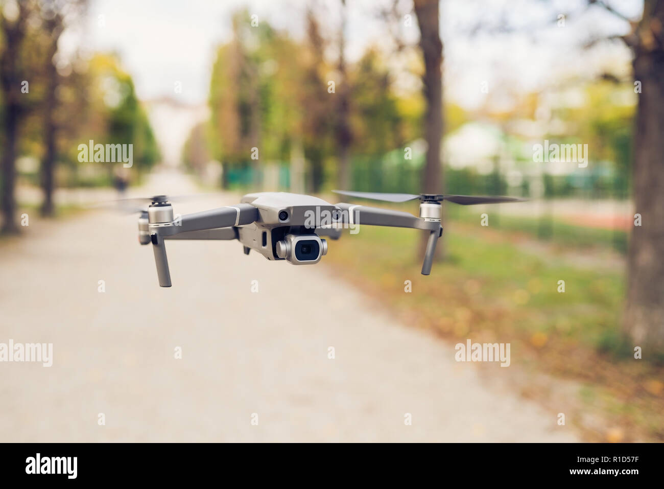 Drone flying in the air in the park alley Stock Photo - Alamy