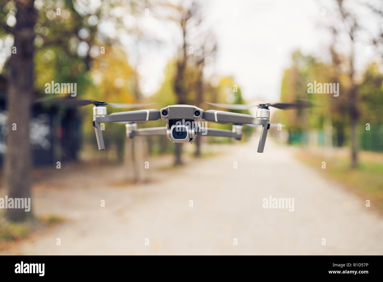 Drone flying in the air in the park alley Stock Photo - Alamy