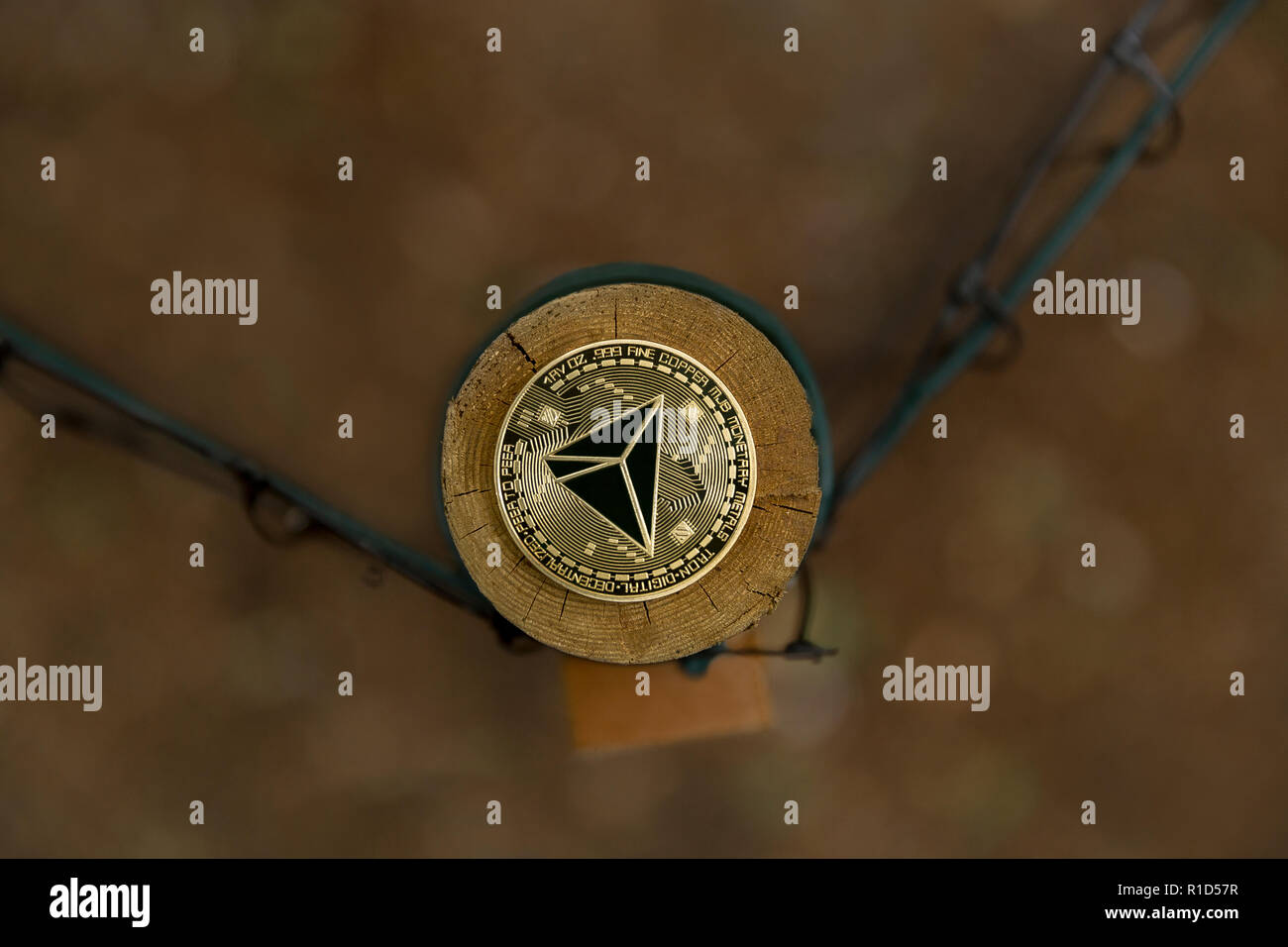Tron cryptocurrency physical coin placed on the top of the fence corner ...