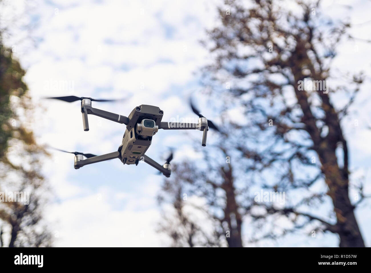 Drone flying in the air, visible trees and blue sky above Stock Photo ...