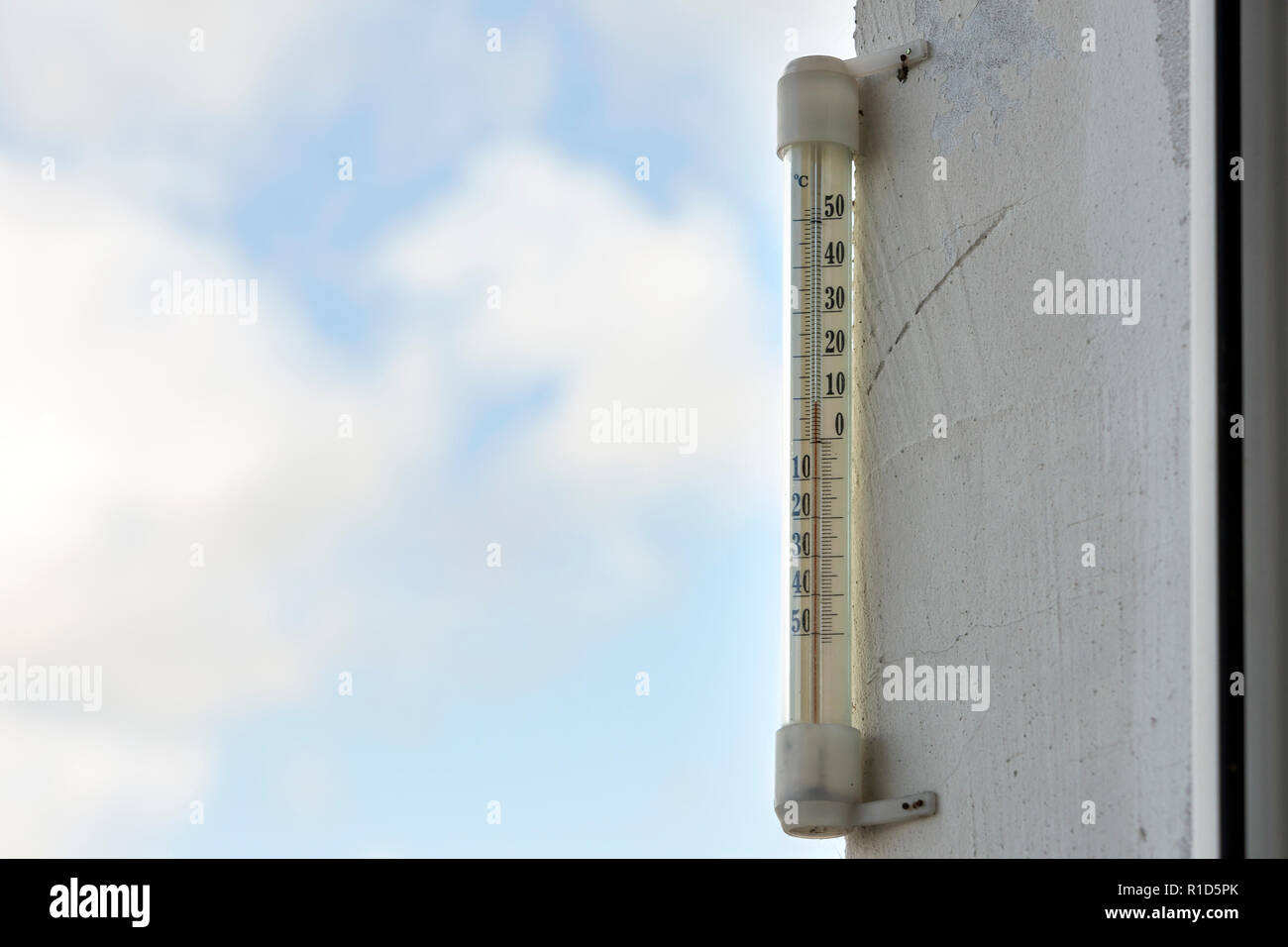 Traditional alcohol glass thermometer Celsius attached to plastered ...