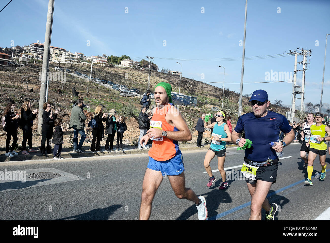 Marathon athletes are seen passing at the region of Mati, the area ...