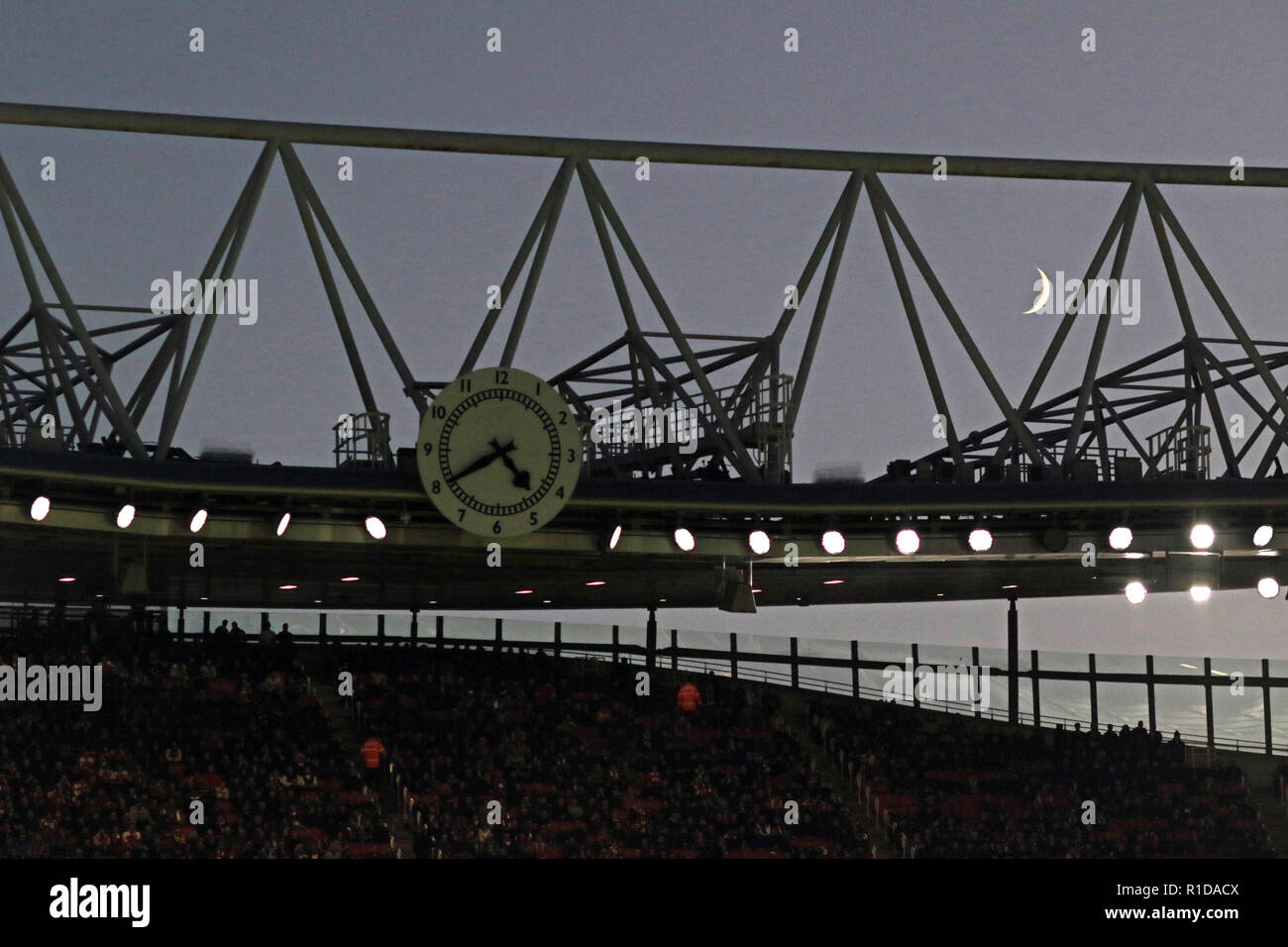 London, UK. 11th Nov 2018. A crescent moon behind the Clock End stand ...