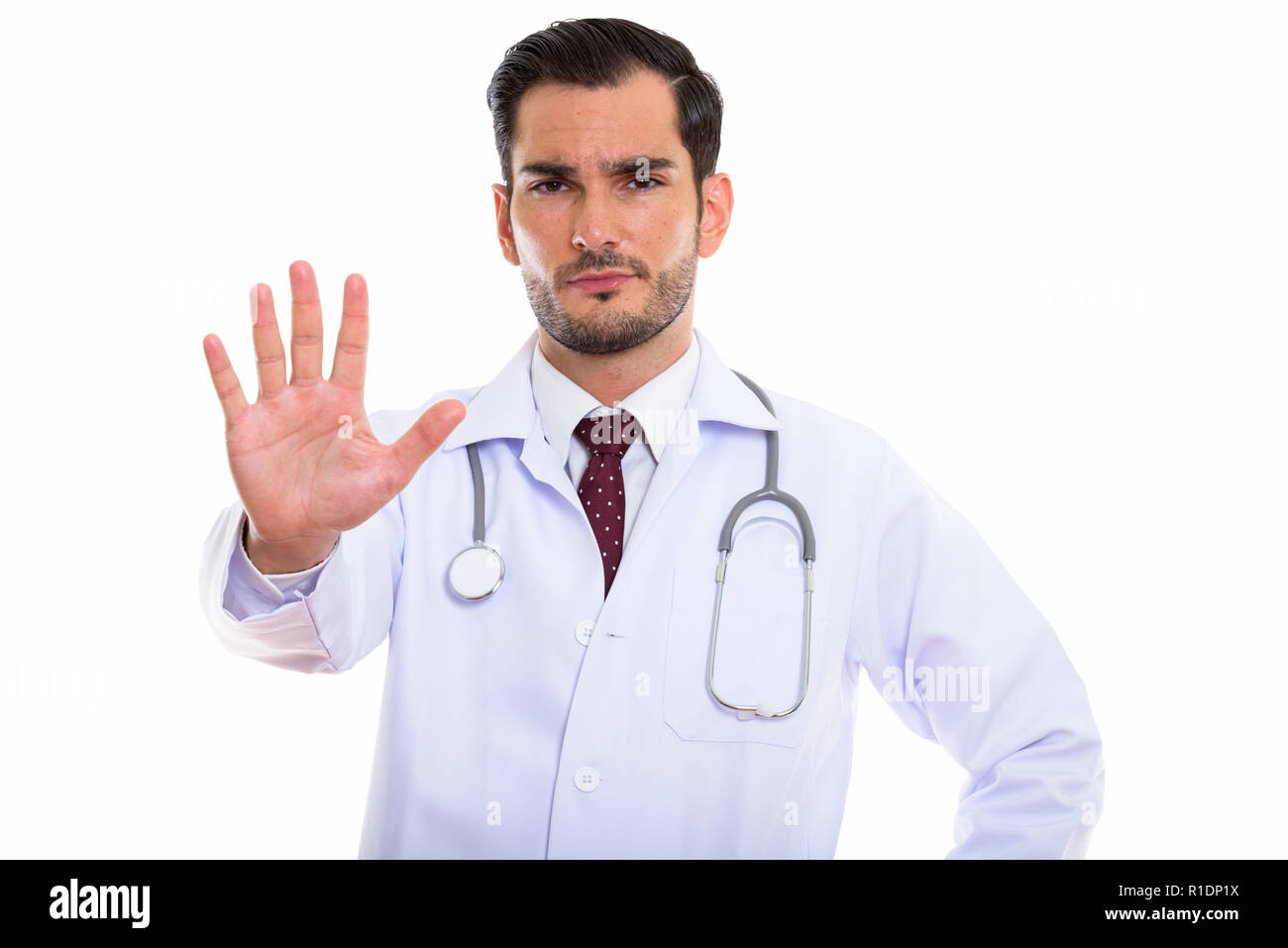 Studio shot of young handsome man doctor showing stop hand sign Stock ...