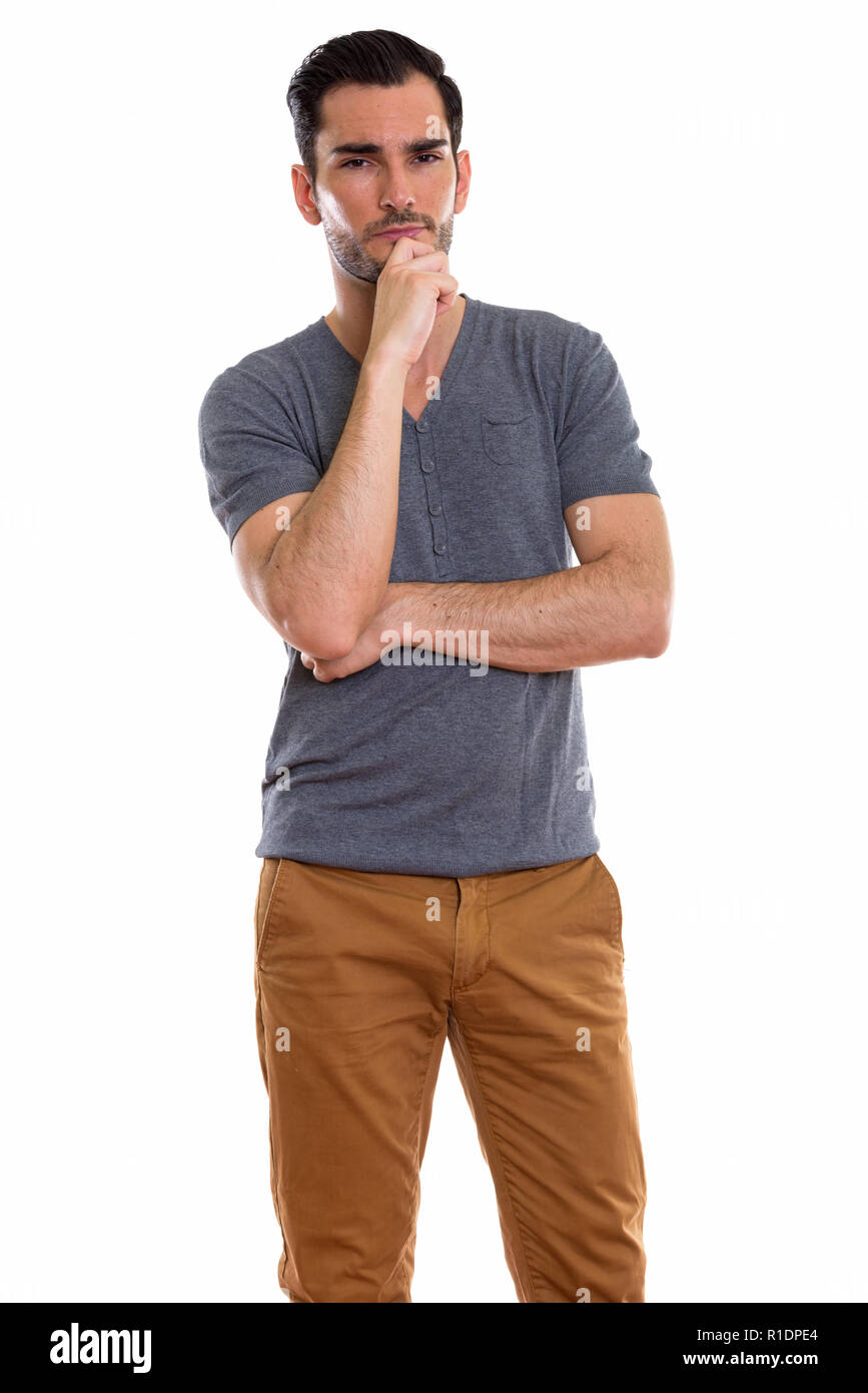 Studio shot of young handsome man standing while thinking Stock Photo ...