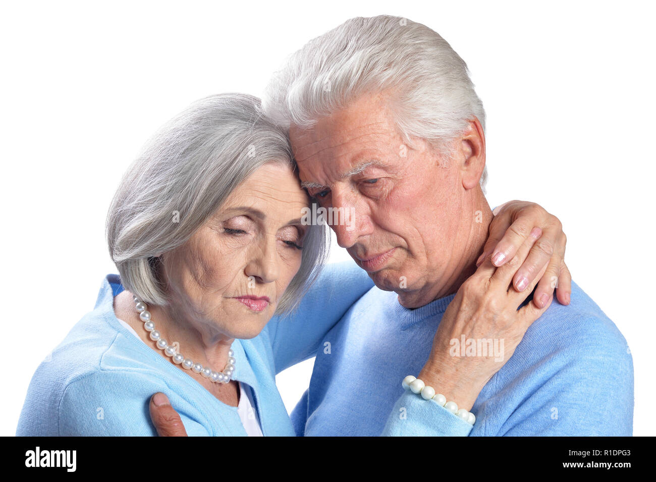 Portrait of sad senior couple hugging on white background Stock Photo ...