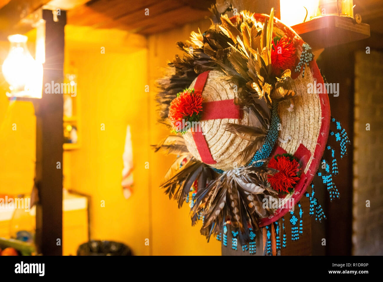 Shaman ritual feather hat hanging on the wall Stock Photo - Alamy