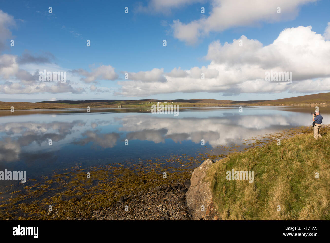 White clouds reflecting in water, Sandsound Voe, Shetland Stock Photo ...