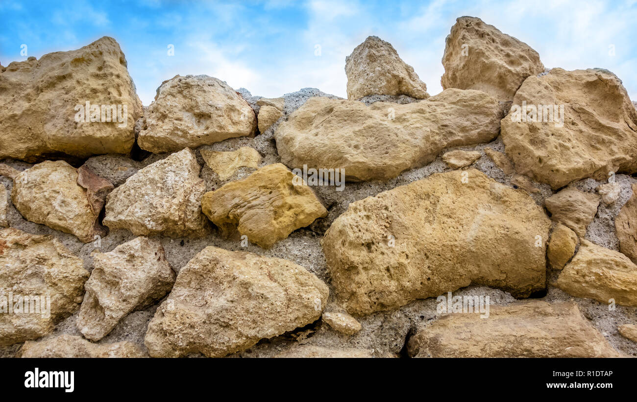 Ancient wall of large rough stones on blue sky background Stock Photo ...