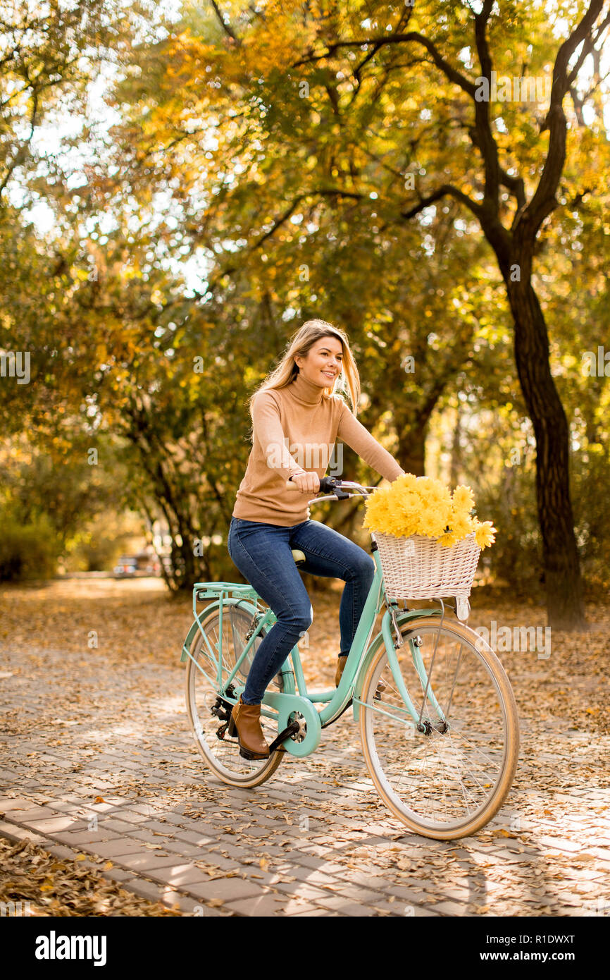 Happy active woman riding bicycle in golden autumn park Stock Photo - Alamy