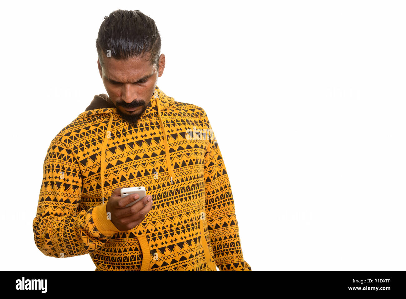 Young Indian man using mobile phone studio portrait against white ...