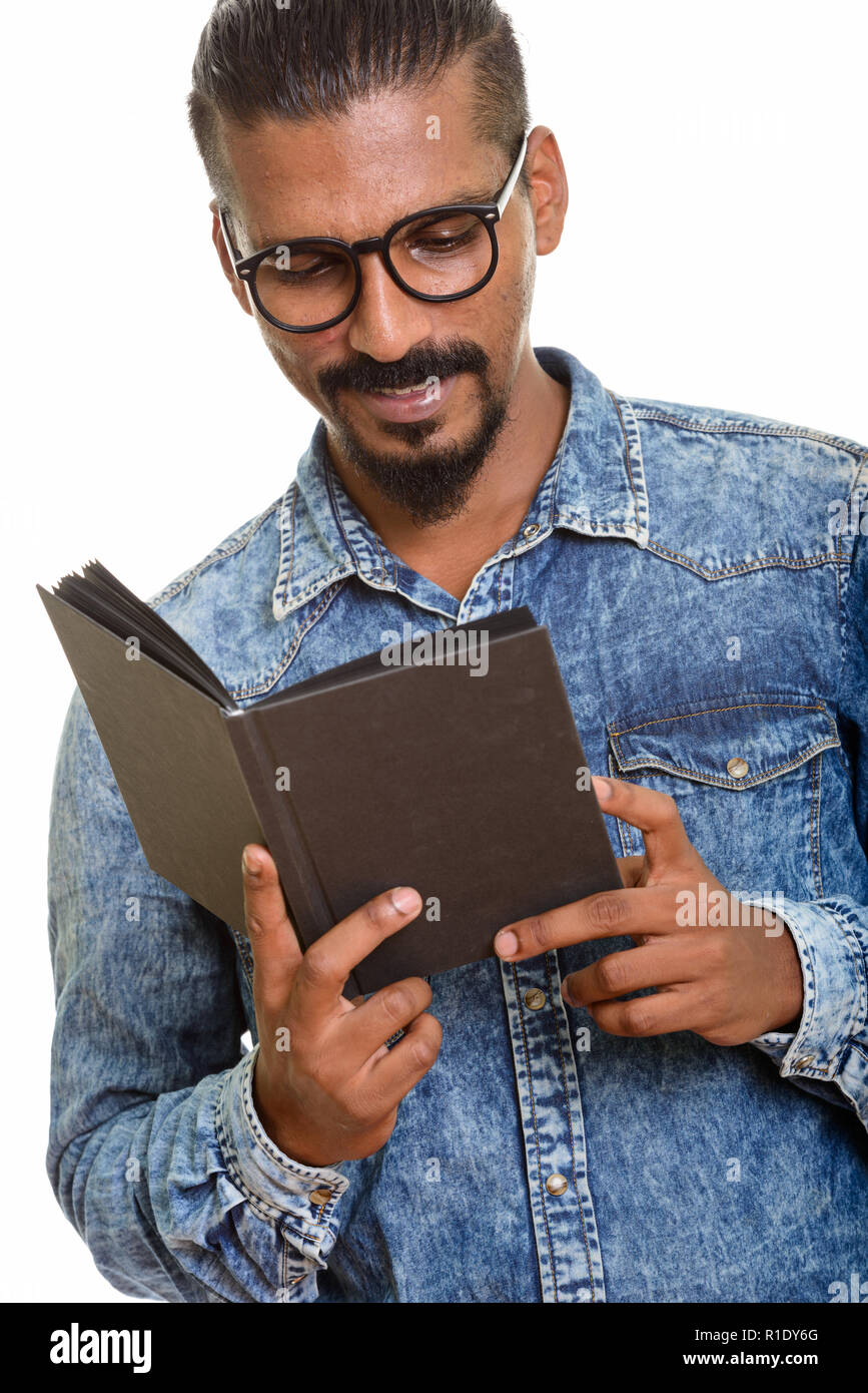Young happy Indian man reading book studio portrait against white ...