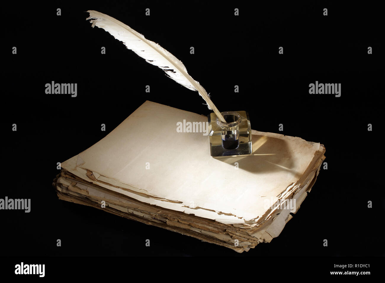 Old quill pen and old papers with inkwell on a black textured ...