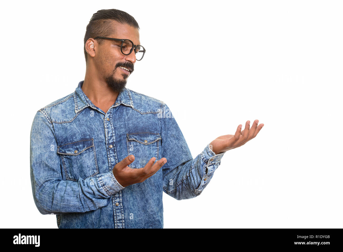 Young happy Indian man showing something studio portrait against white ...