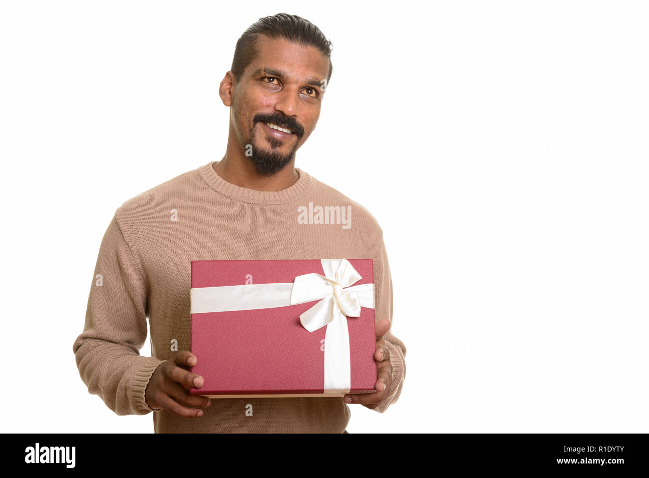 Young happy Indian man holding gift box while thinking ready for Stock ...
