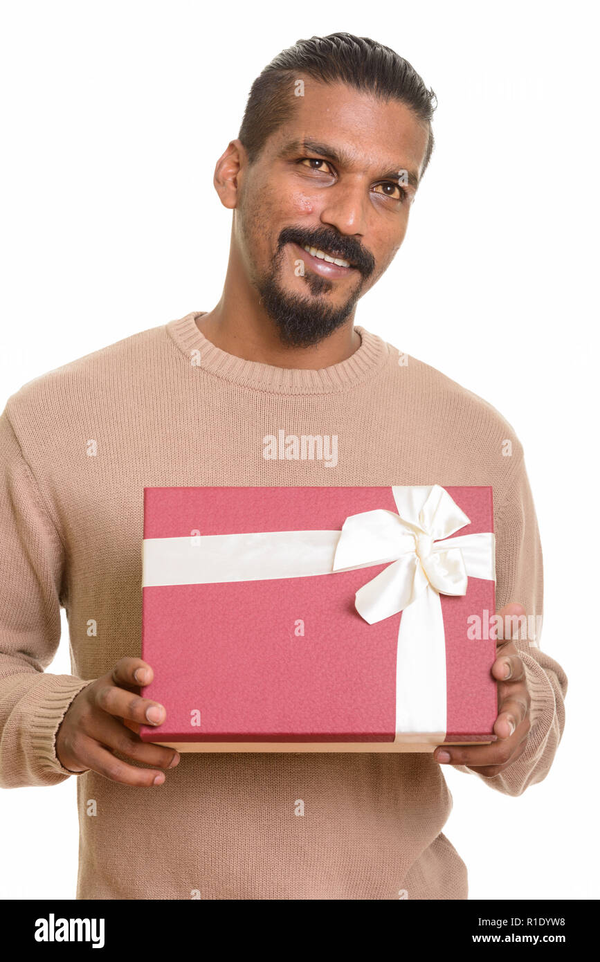 Young happy Indian man holding gift box while thinking ready for Stock ...