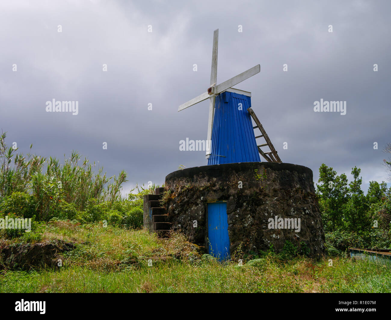 Image of blue wooden wind mill on a stone base with blue door Stock ...