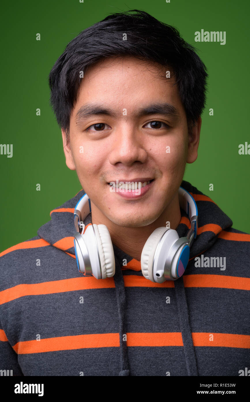 Young handsome Filipino man against green background Stock Photo - Alamy