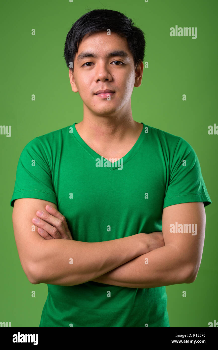 Young handsome Filipino man against green background Stock Photo - Alamy