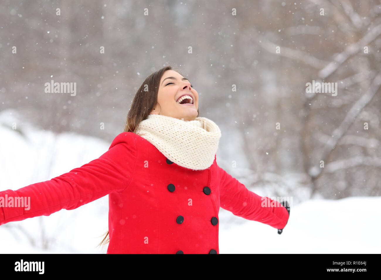 Joyful woman breathing fresh air enjoying snow in a snowy mountain ...