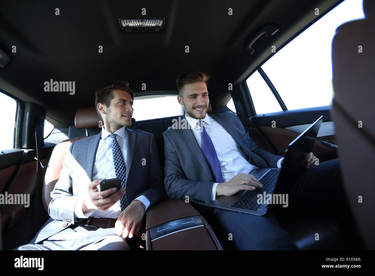 business colleagues talking, sitting in the back seat of a car Stock ...