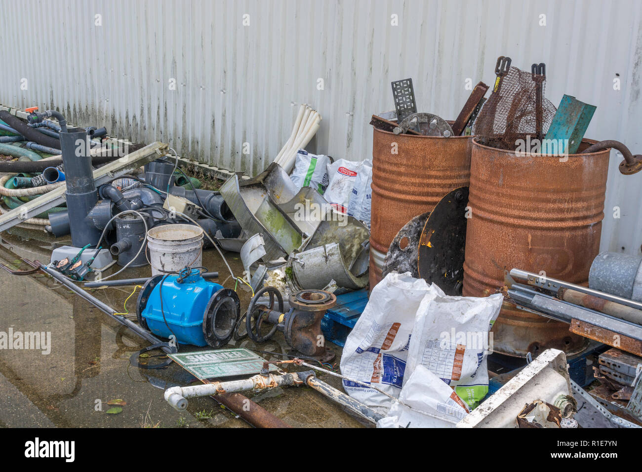 Pile of industrial waste piled up beside building wall. Some brand ...