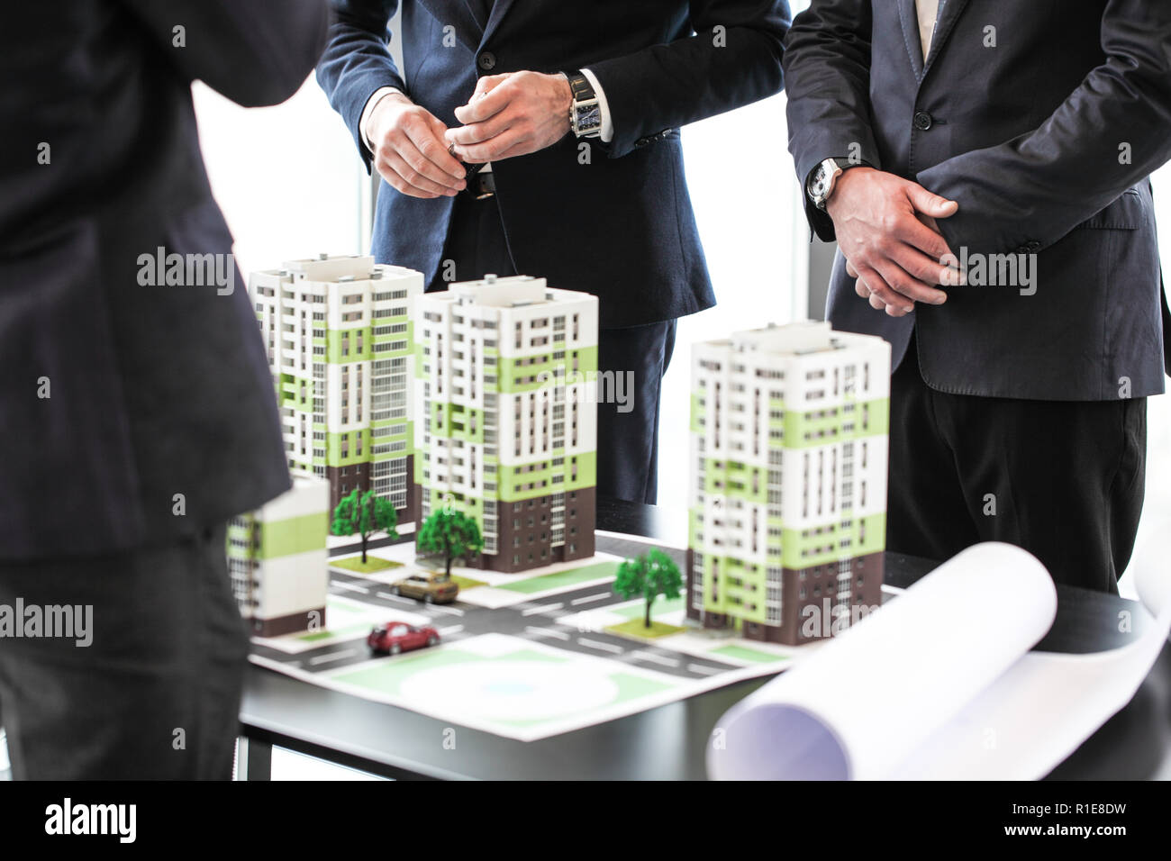 Business meeting of architects and investors looking at model of ...