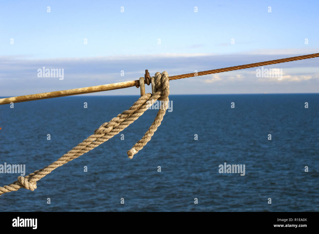 ship ropes with a knot on big blue sea background Stock Photo - Alamy