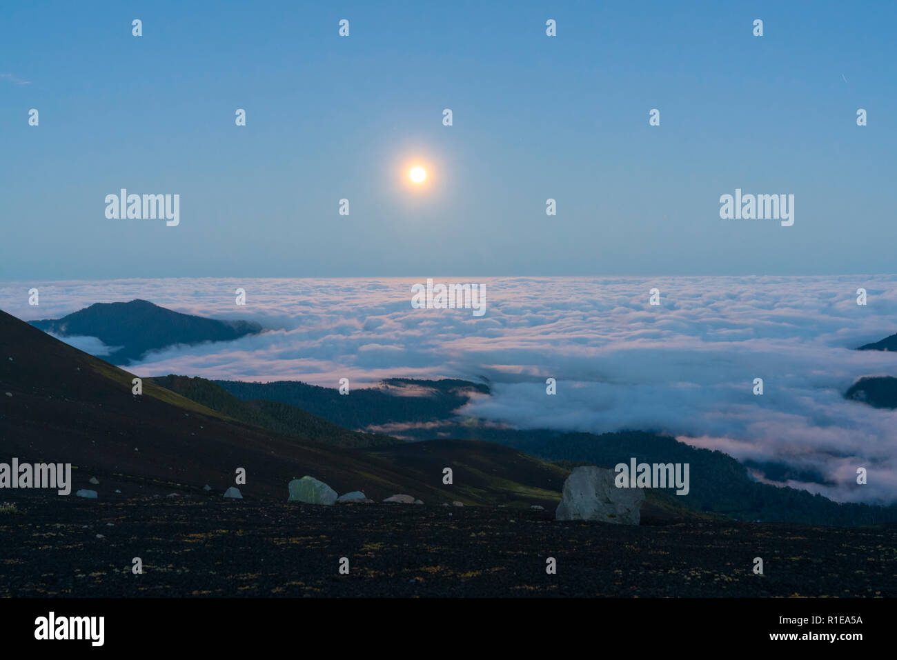 full moon hiding on a sea of clouds, seen from the heights of the Andes ...