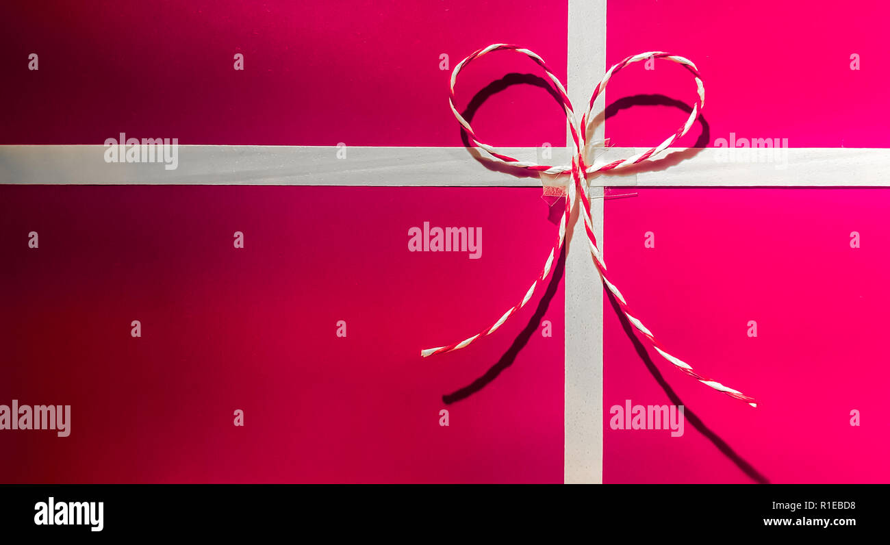 Front view of pink and red color decorated gift box with ribbons and ...