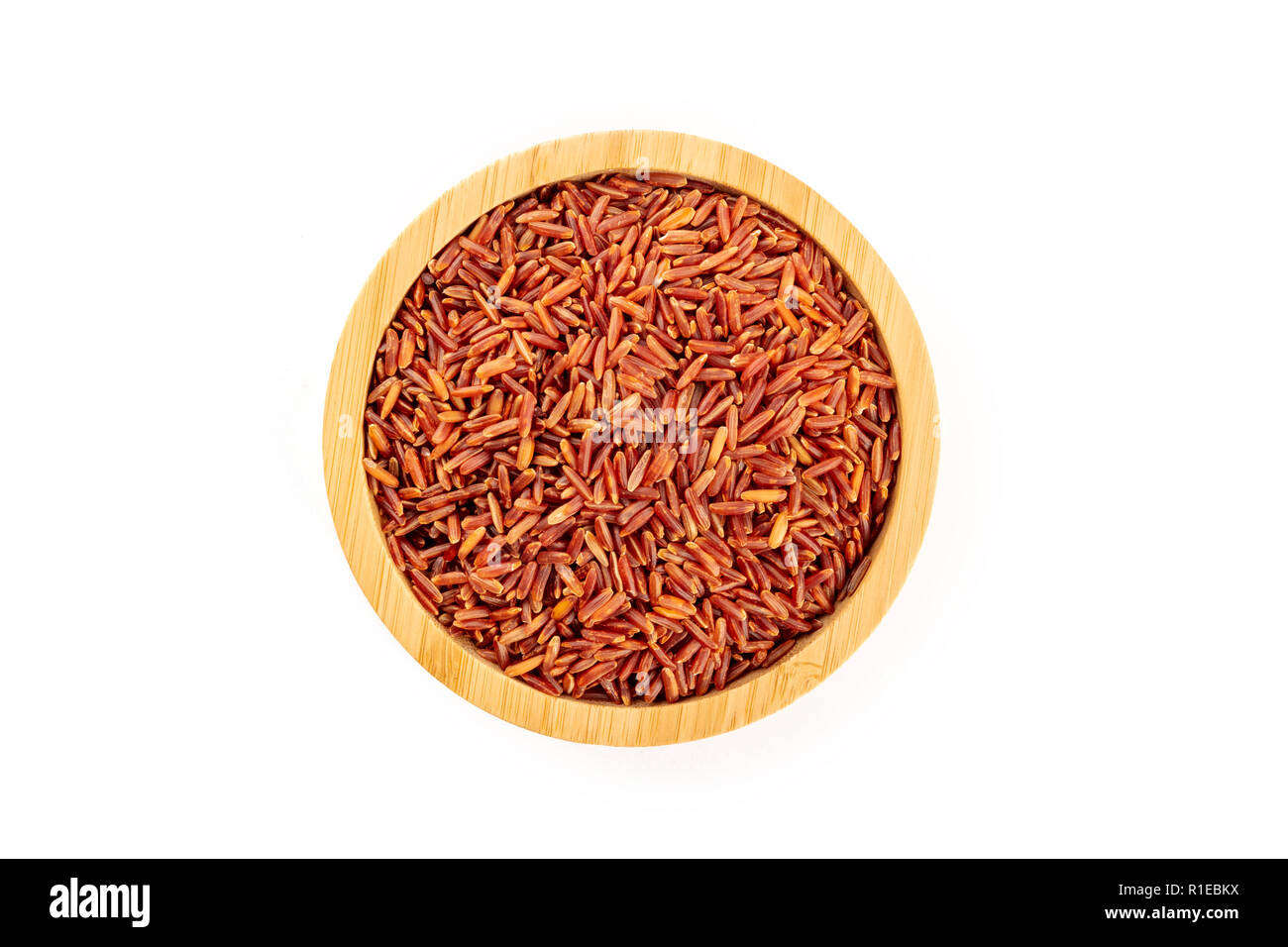 Red rice, shot from the top in a wooden bowl on a white background with ...