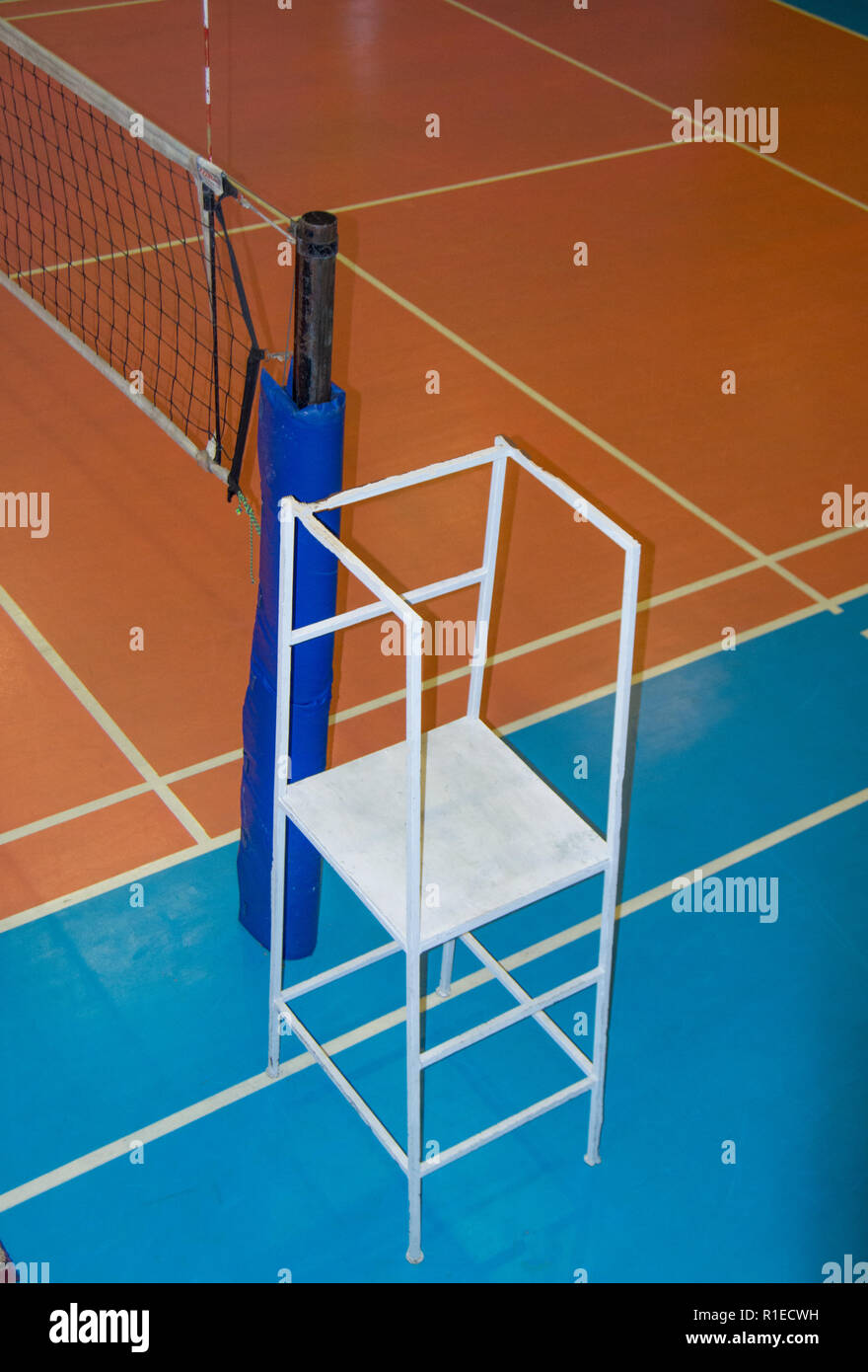 Empty sports hall with a stretched volleyball net and a tower for the ...