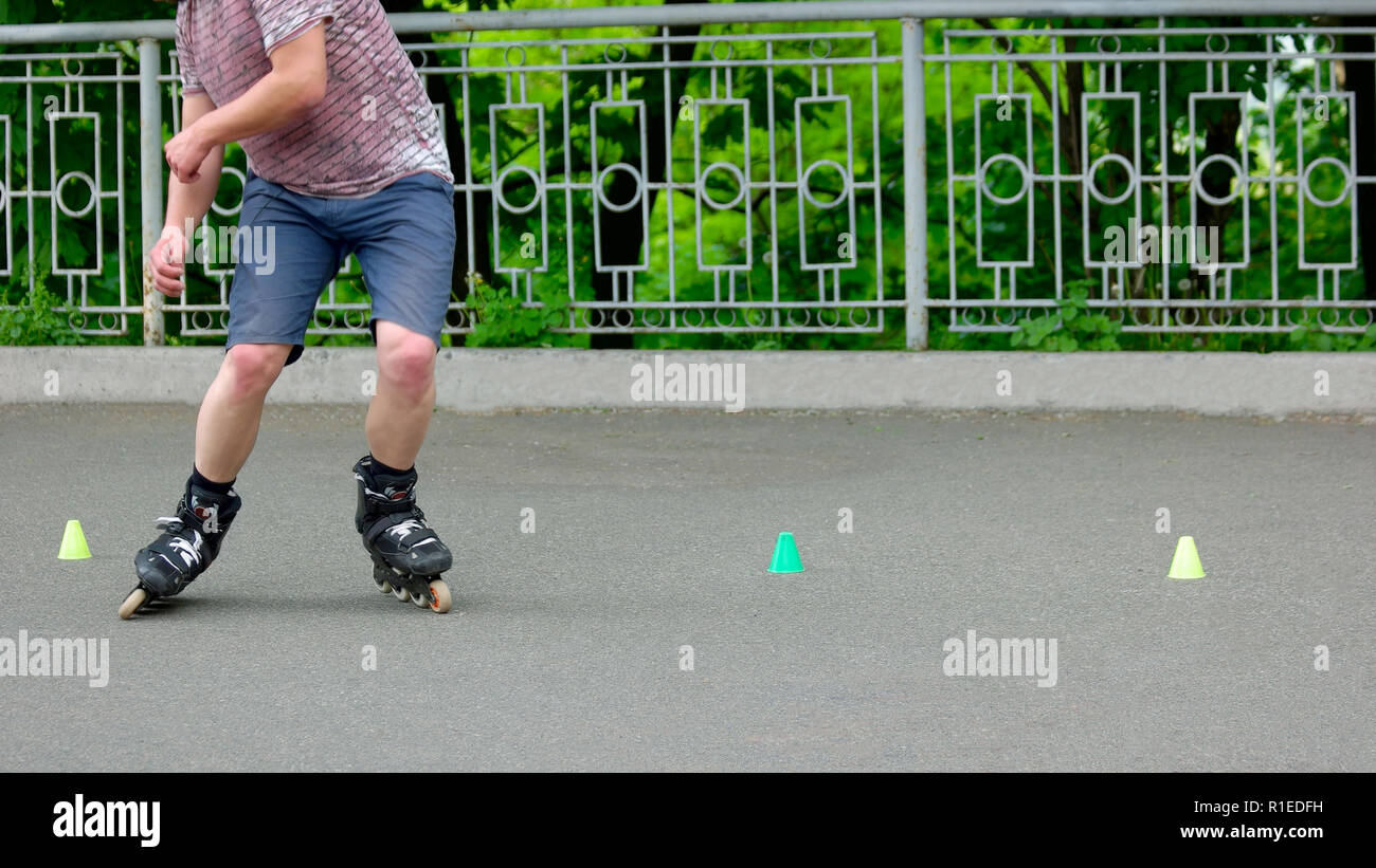 Boy riding on rollers in the summer park Stock Photo - Alamy