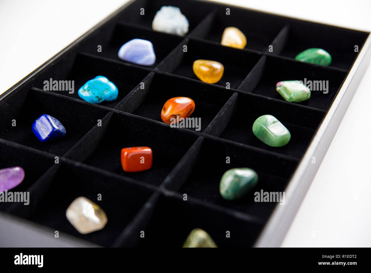 Variety of colorful semi precious stones crystals in organizer box ...
