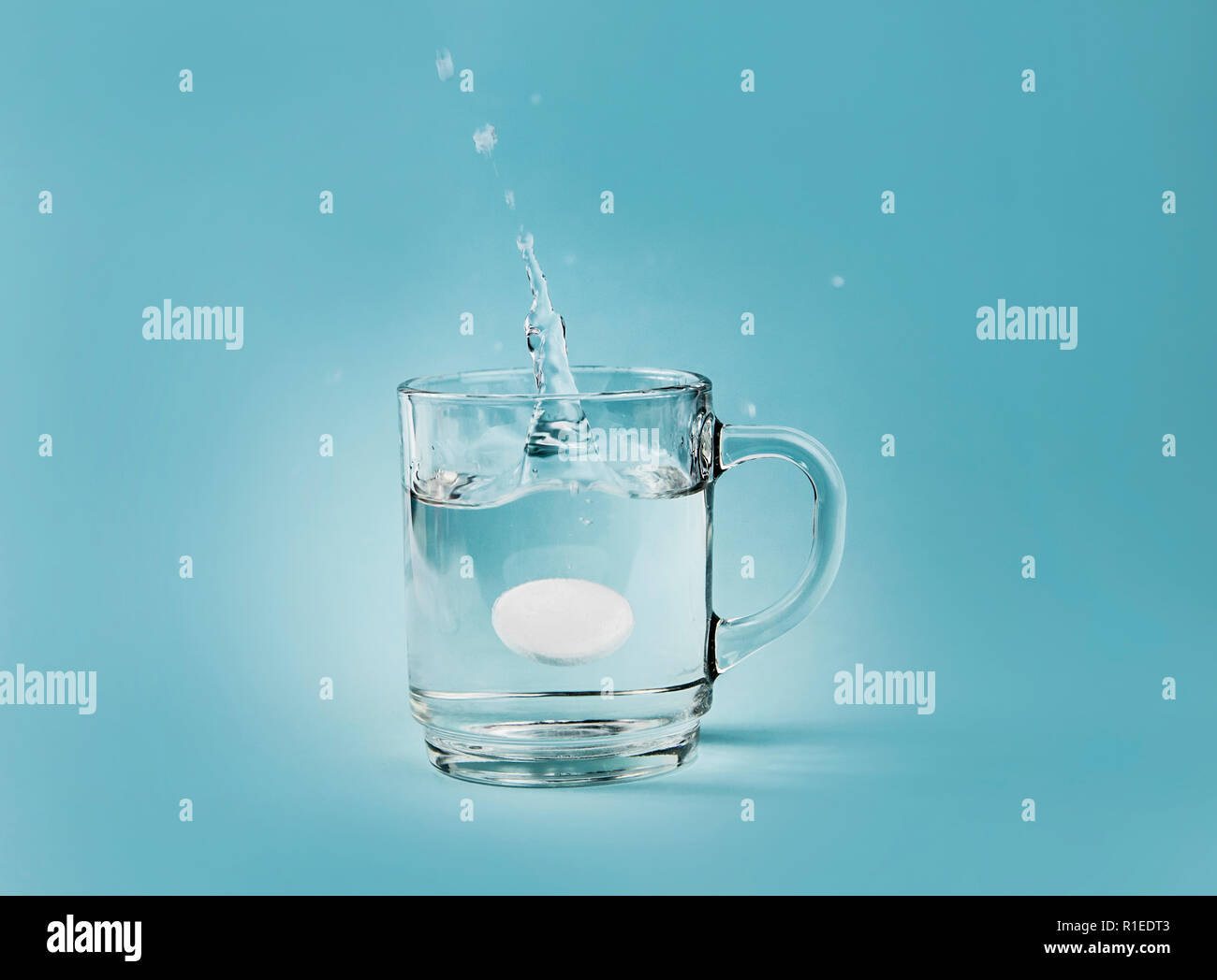 Side view of soluble pain killer tablet drop in water splashing, whole ...