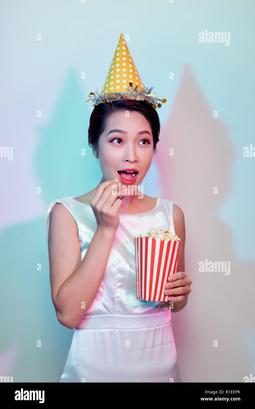 Amazing cute young pretty girl on the light background eats popcorn ...
