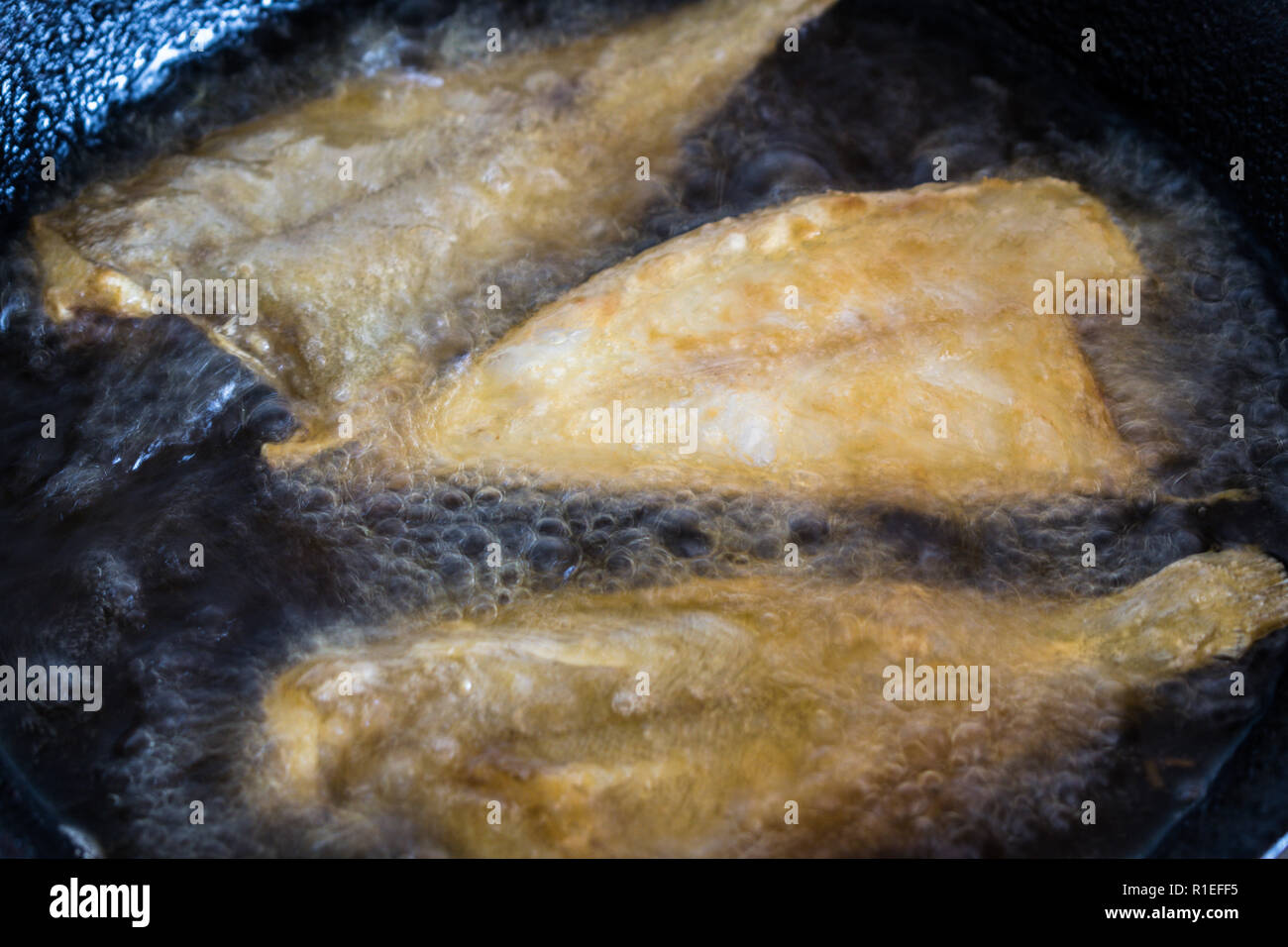 Frying fish in the pan with boiling oil Stock Photo - Alamy