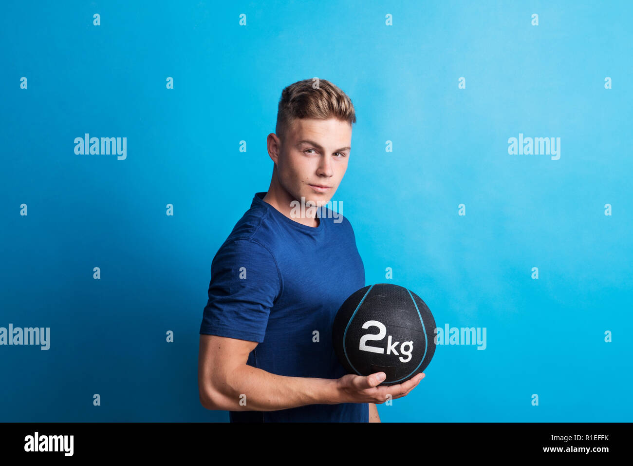 Portrait of a young man with heavy ball in a studio Stock Photo - Alamy