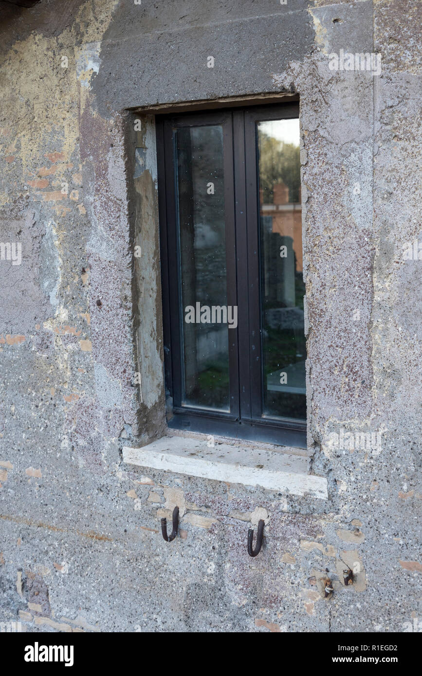 The window on the side of the concrete wall. The window of an old ...