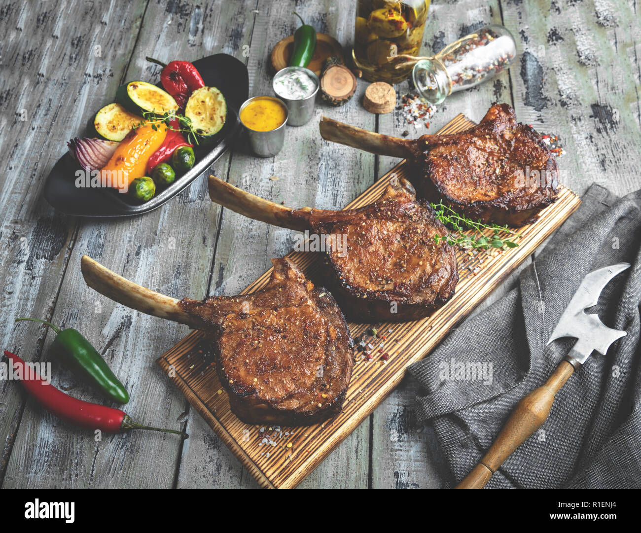 Grilled lamb,mutton meat chops with vegetables on a serving board ...