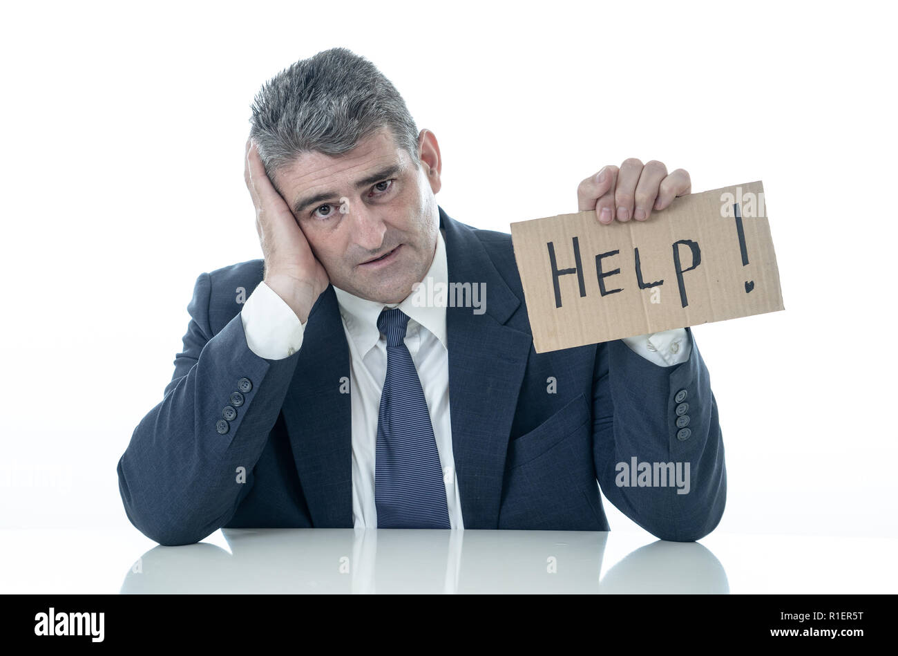 Helpless mature businessman holding a help sign in financial crisis ...