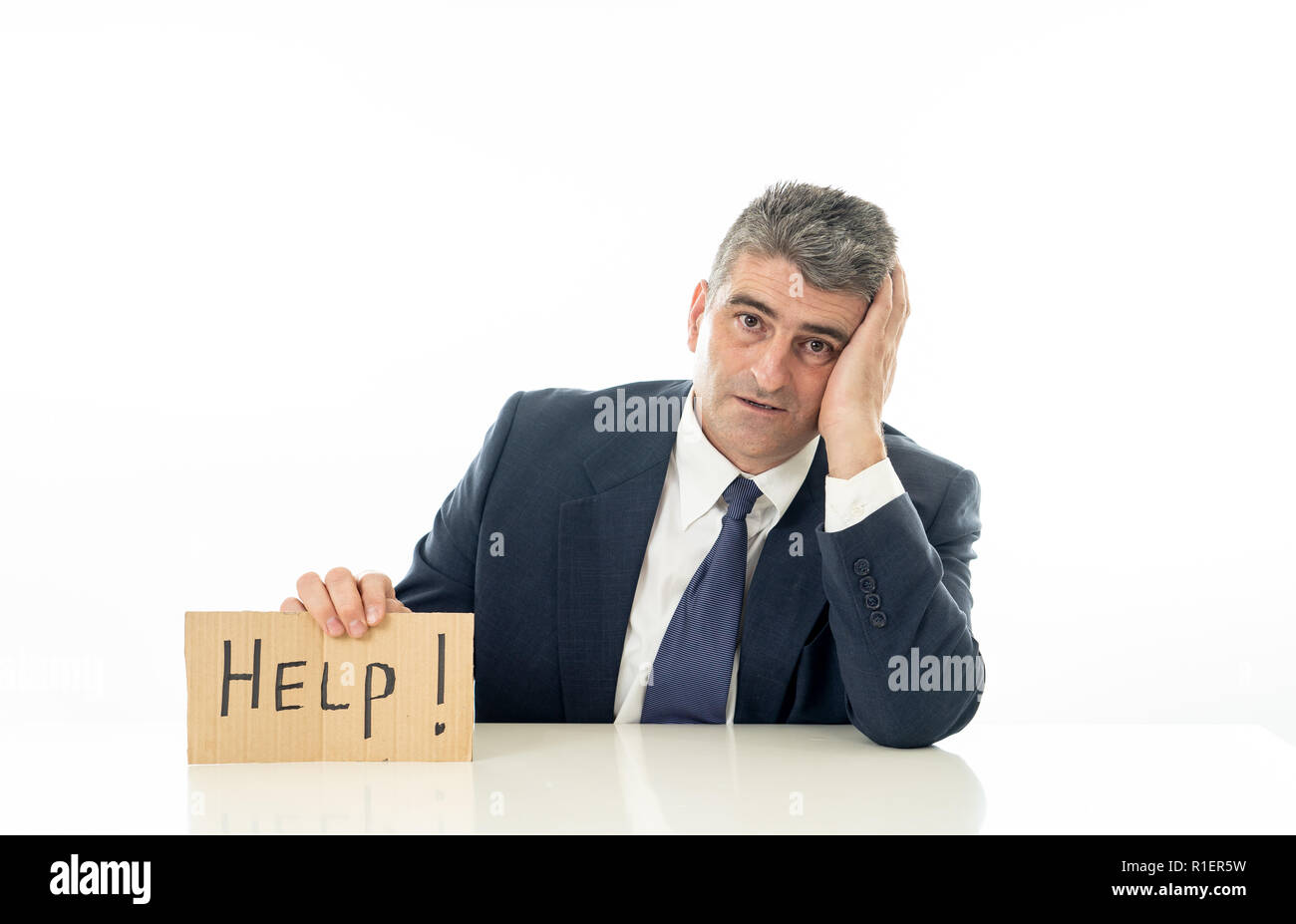 Helpless mature businessman holding a help sign in financial crisis ...