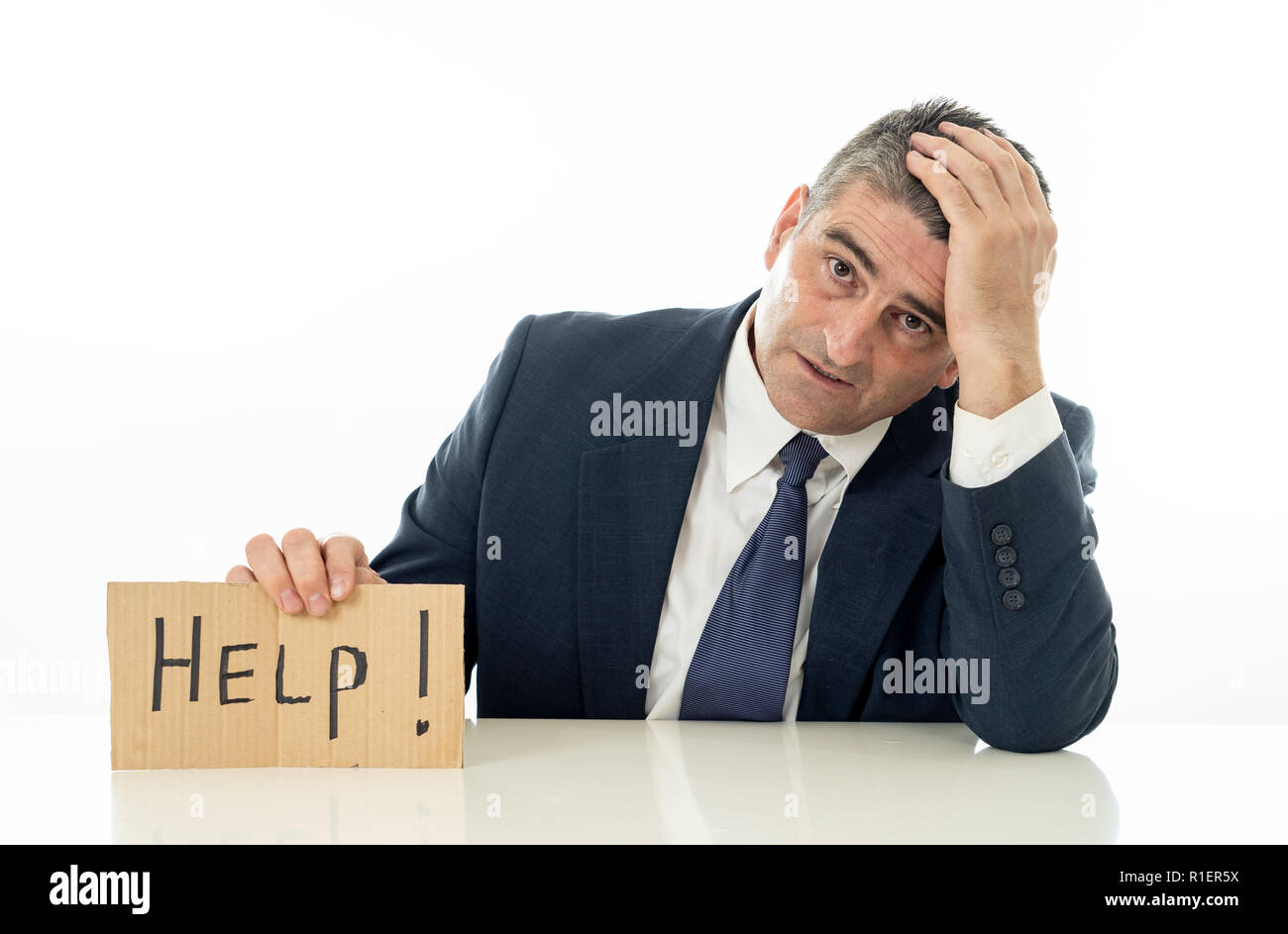 Helpless mature businessman holding a help sign in financial crisis ...