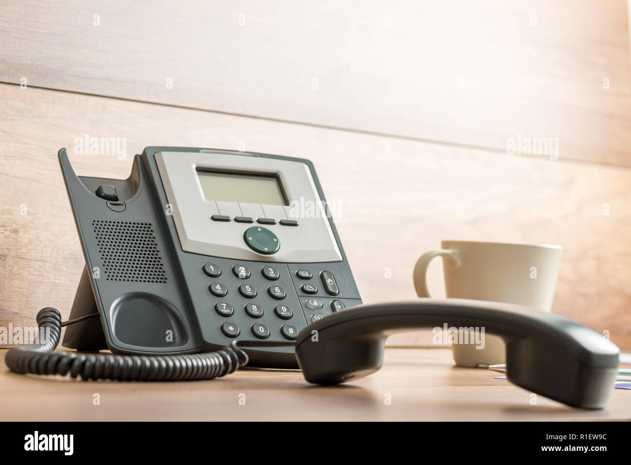 Black landline telephone with handset off line on wooden office desk ...
